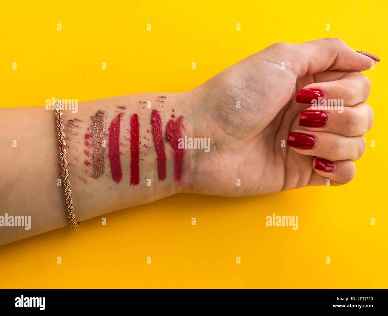 hand of makeup artist with bright red manicure. applying makeup to the ...