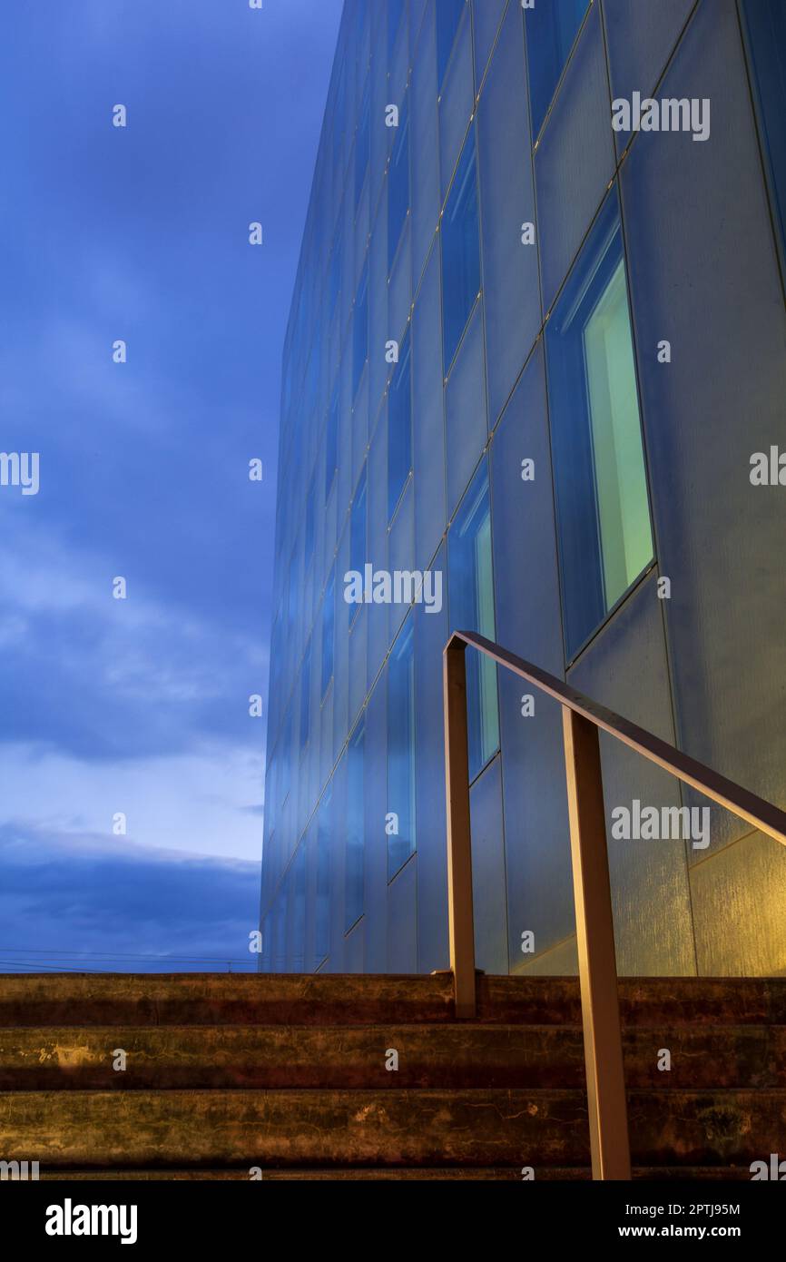 Modern architecture in cold blue light of twilight hour and warm light ...