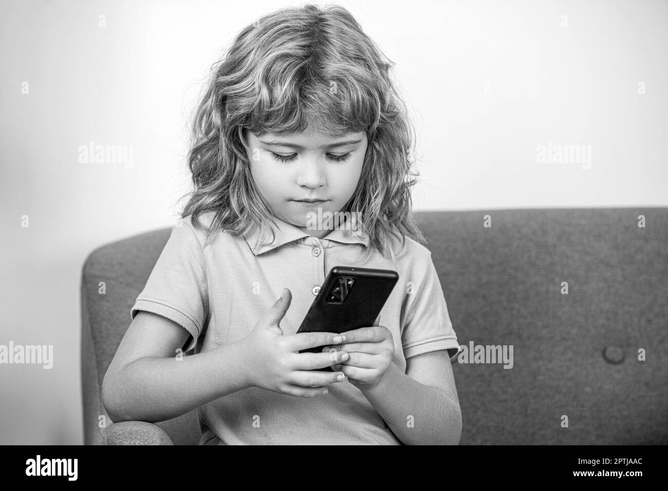Little boy using smartphone, looking at screen, child holding phone in ...