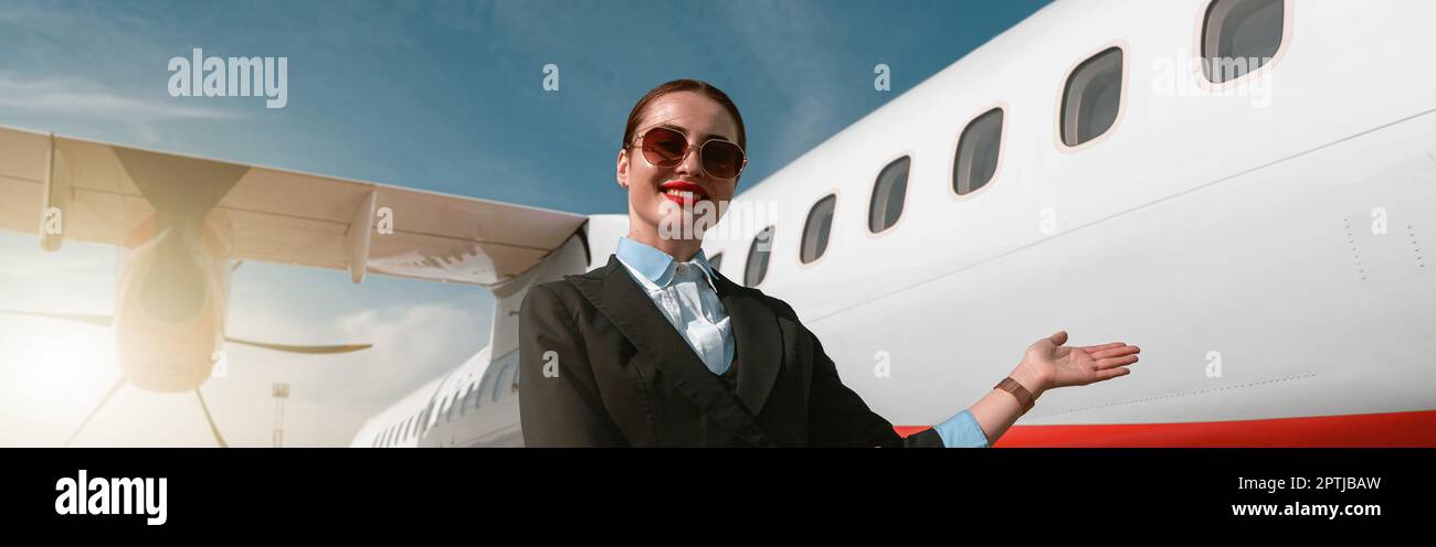 Woman stewardess standing near airplane and inviting on board Stock ...