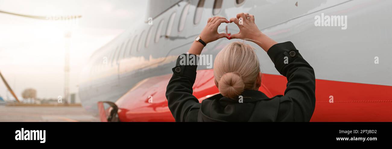 Back view of flight attendant looking on aircraft and showing sign ...