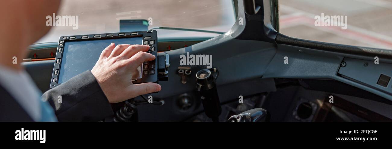 Aircraft pilot sitting in cockpit and using flight display Stock Photo ...