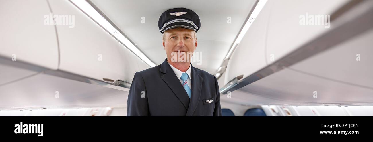 Male pilot standing in passenger airplane cabin Stock Photo - Alamy