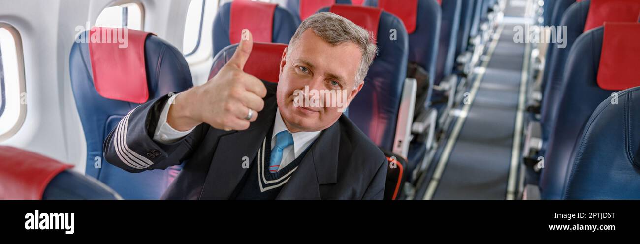 Male aircraft pilot sitting on passenger seat and giving thumbs up ...