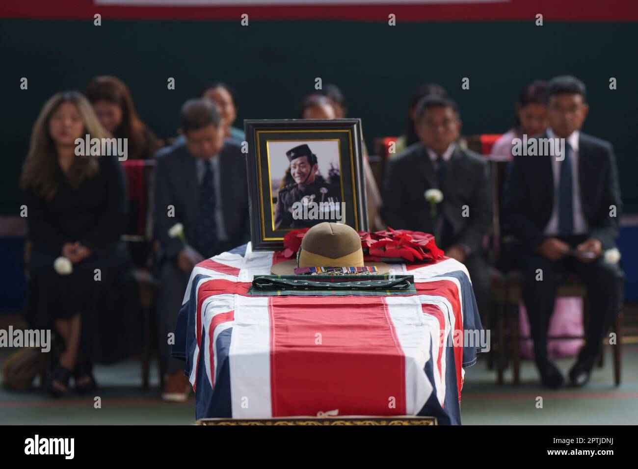 Family members sit next to the coffin of Rambahadur Limbu at the ...
