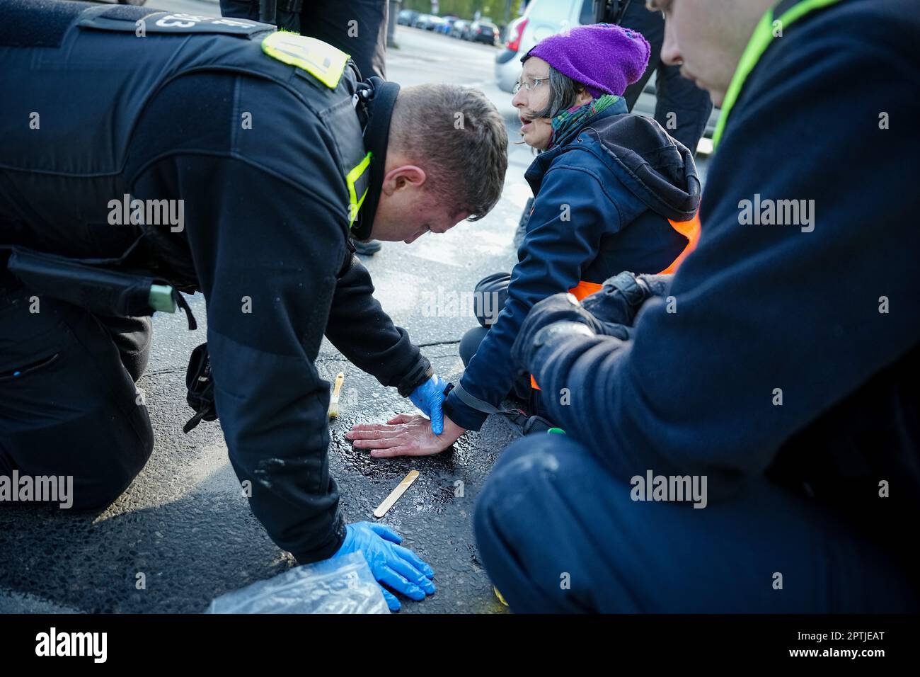 Berlin, Germany. 28th Apr, 2023. A police officer removes the hand of a ...
