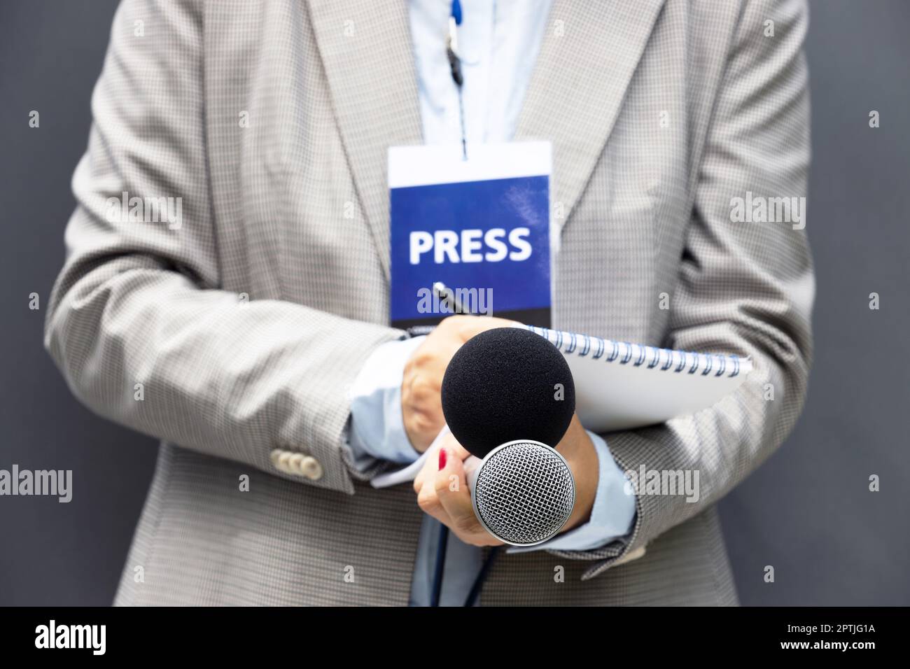 Female journalist at news conference or media event, writing notes ...