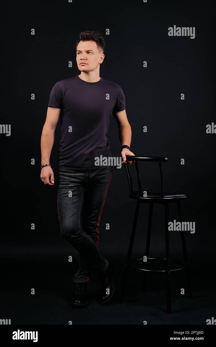 Full length portrait in low key of man standing near the chair Stock ...