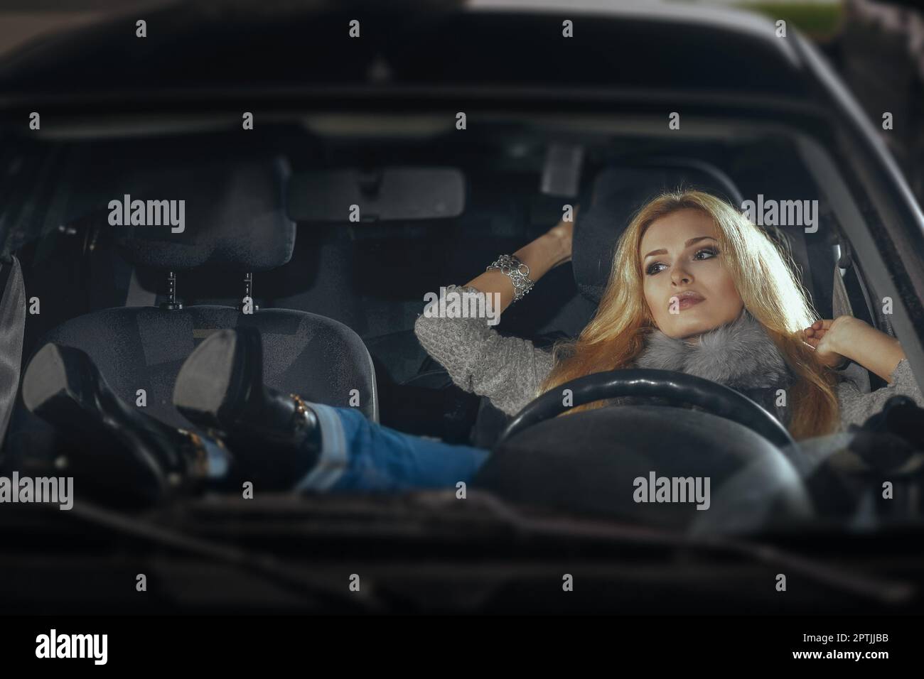 City portrait of pretty blonde driver inside the car. Night scene. Lady ...