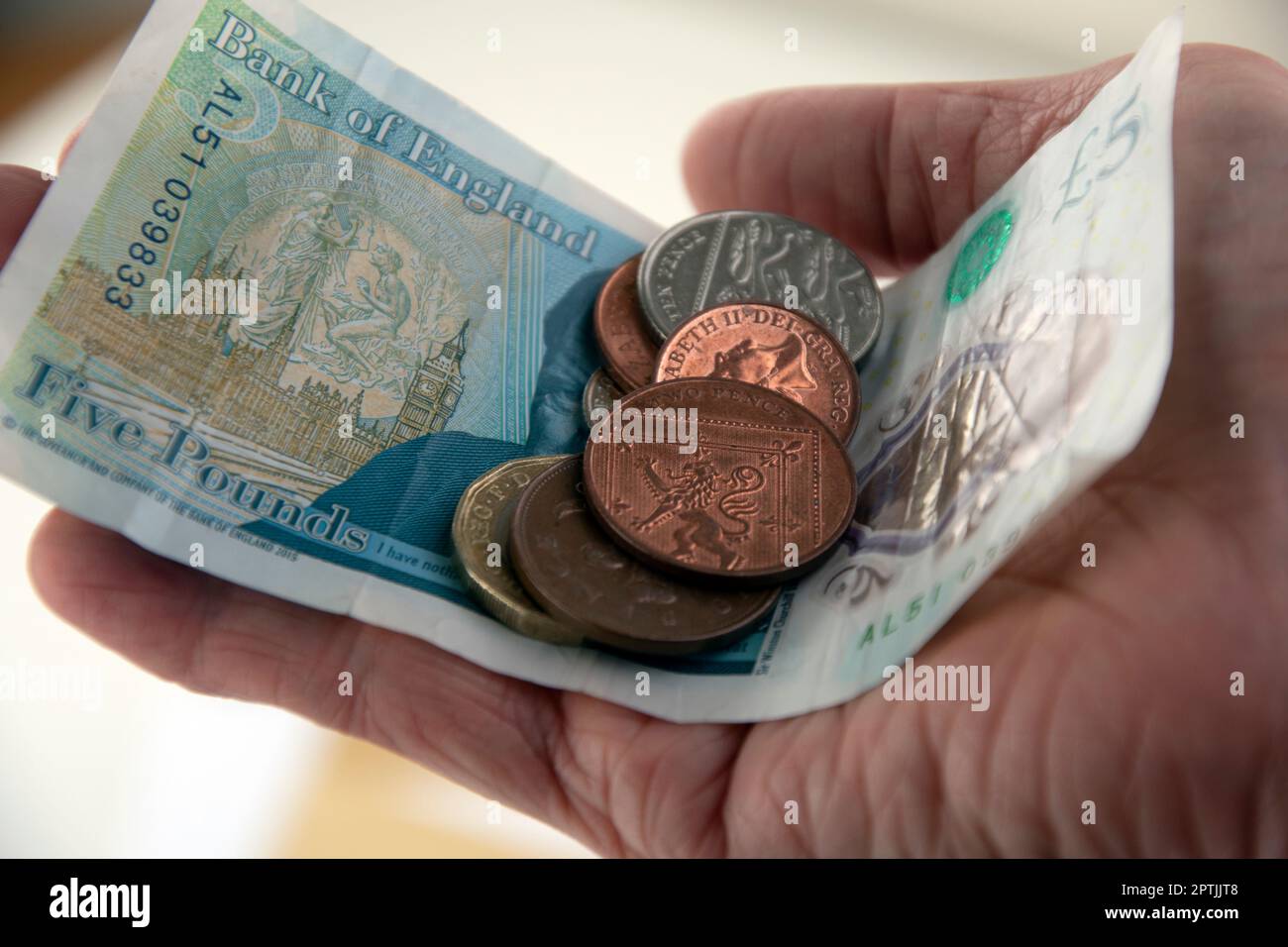 Collection of British bank notes and coins in open hand Stock Photo - Alamy
