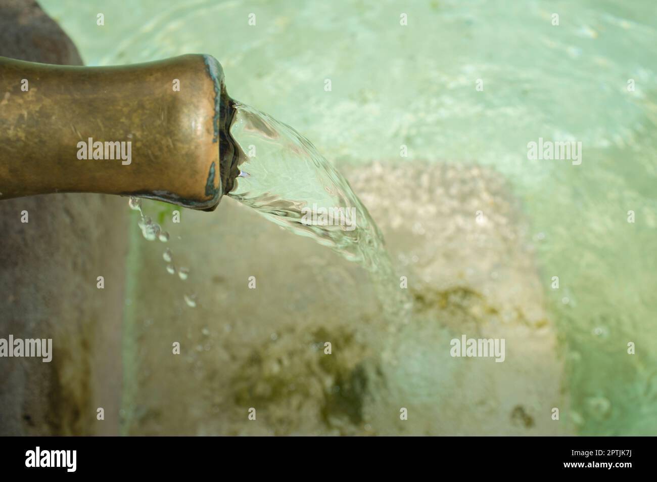 Water permanently flowing from a pipe of a public fountain. Concept of ...