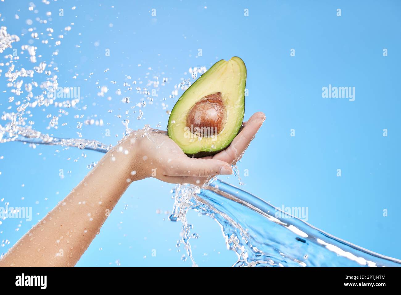 Hand, water and avocado for beauty splash and organic skincare product ...