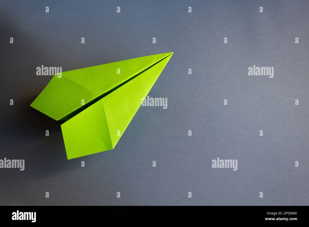 Green paper plane origami isolated on a blank grey background Stock ...