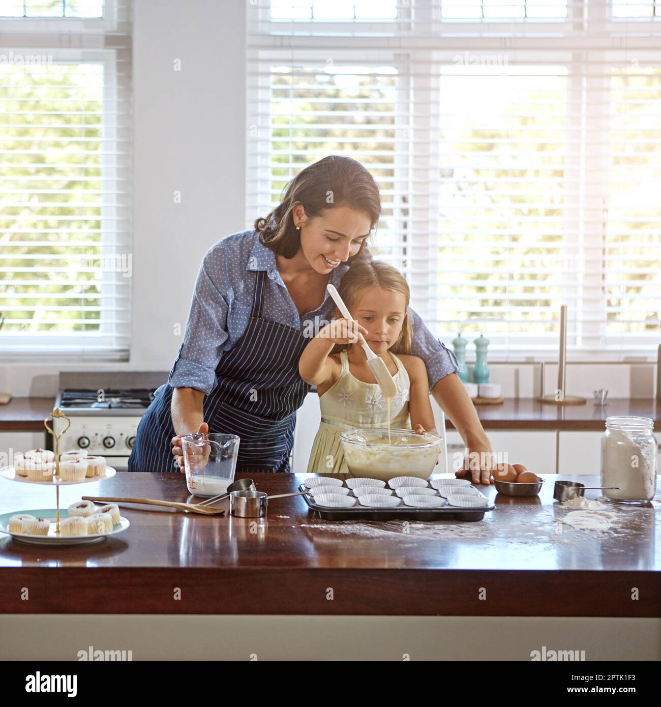 Learning how to bake with mom. a mother and her daughter baking in the ...