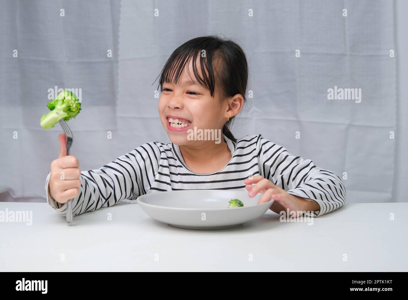 Children love to eat vegetables. Cute Asian girl eating healthy ...