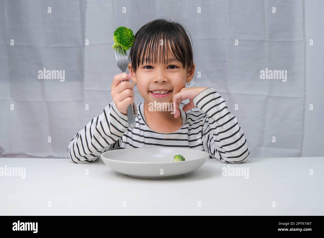 Children love to eat vegetables. Cute Asian girl eating healthy ...