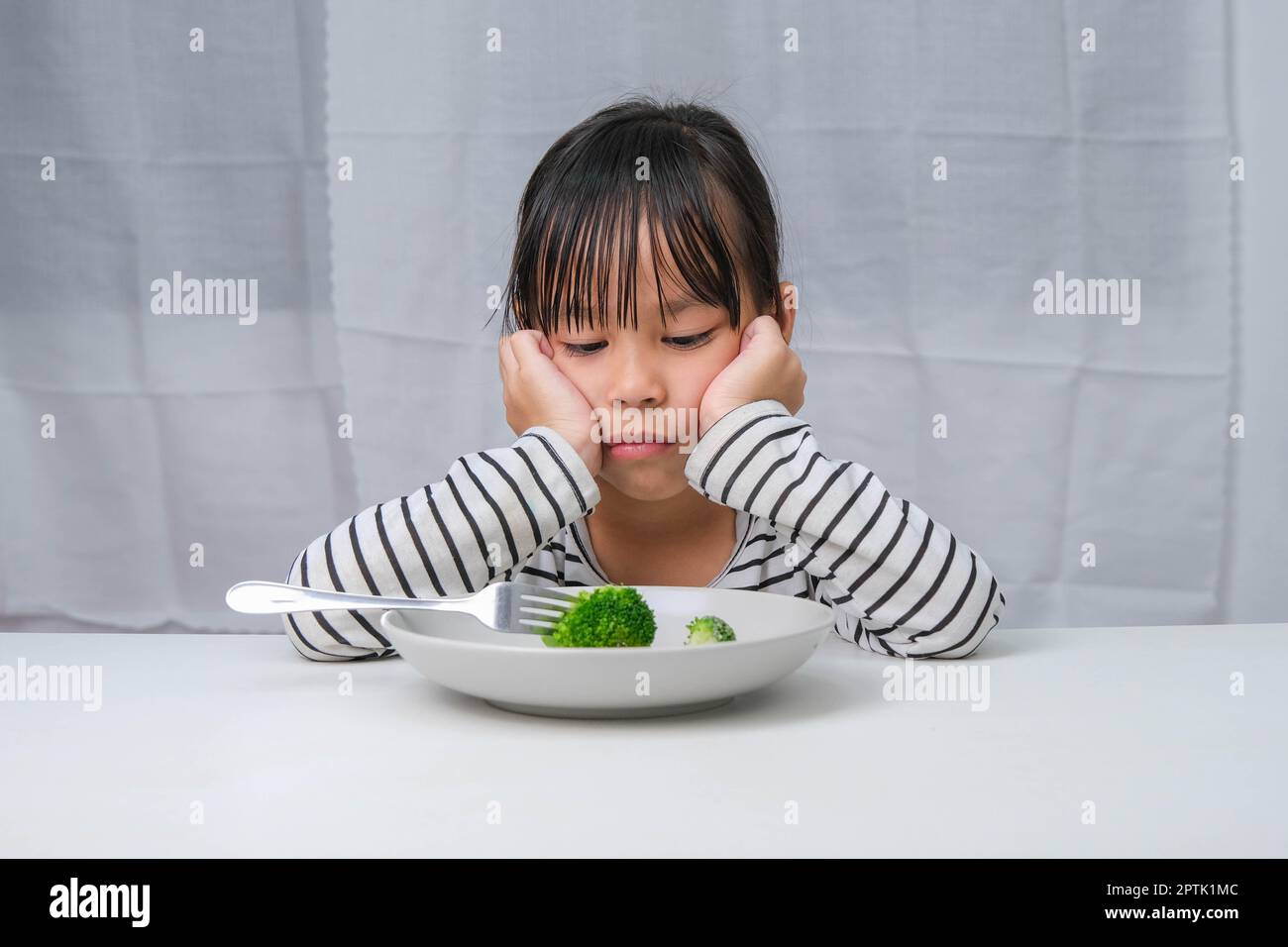 Children don't like to eat vegetables. Cute Asian girl refusing to eat ...