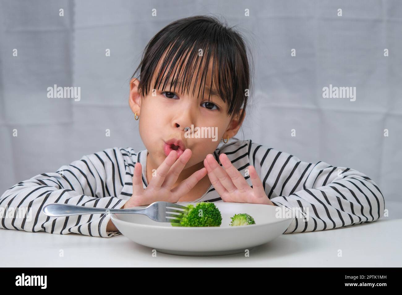 Children don't like to eat vegetables. Cute Asian girl refusing to eat ...