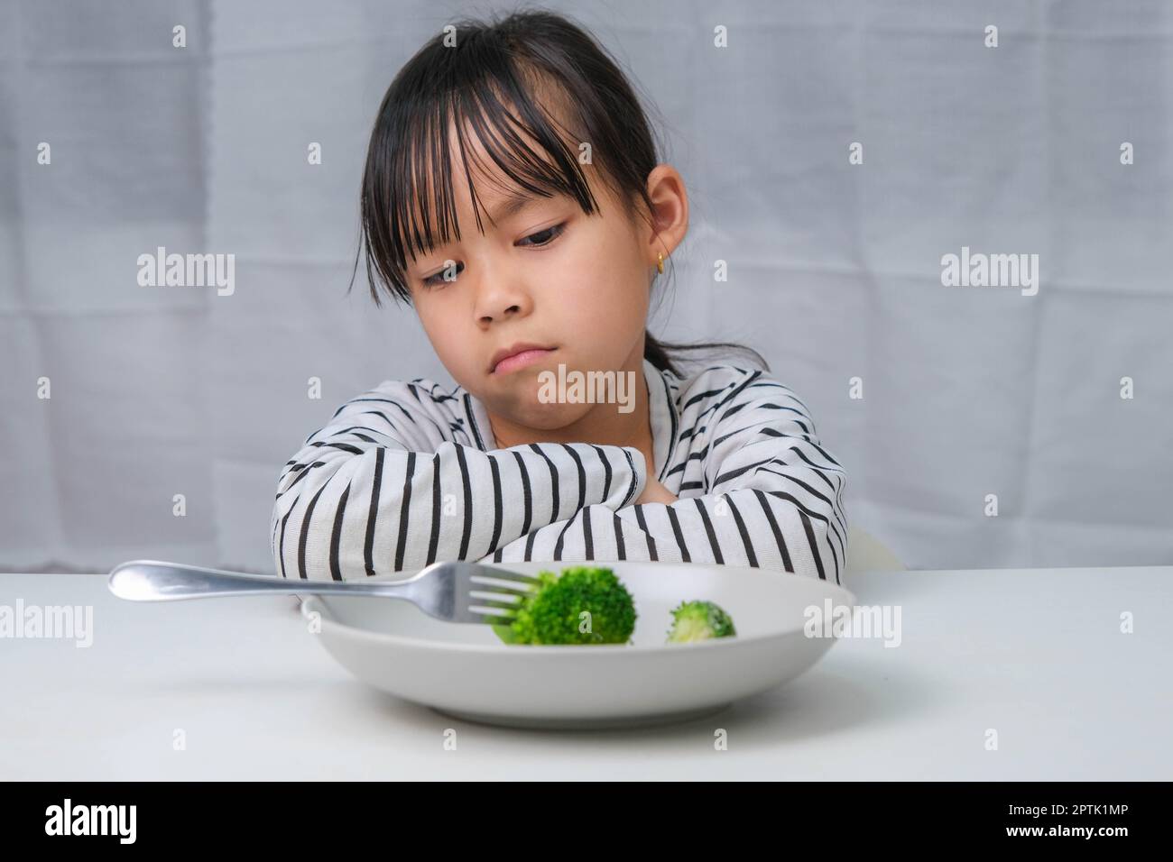 Children don't like to eat vegetables. Cute Asian girl refusing to eat ...