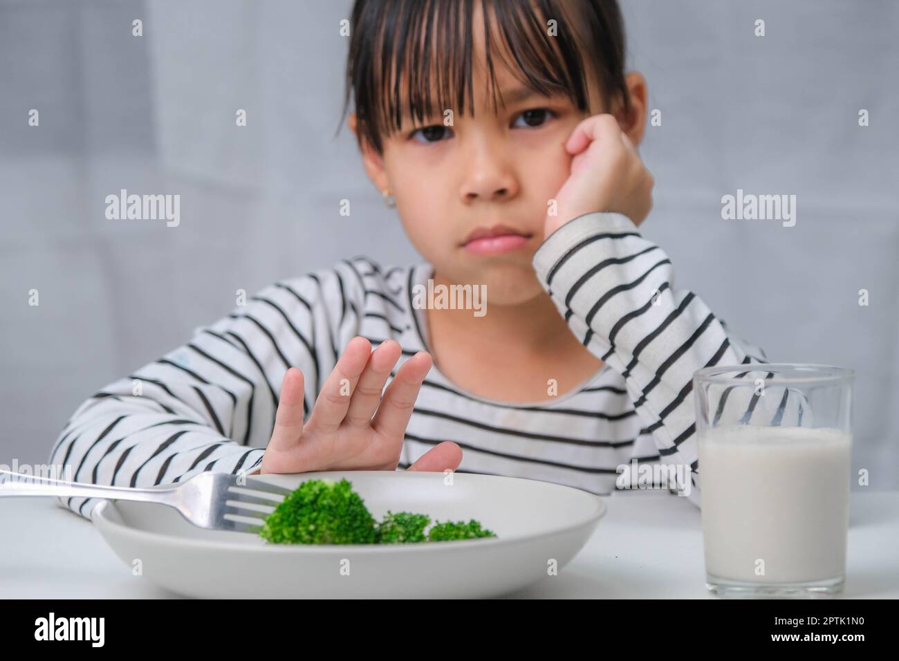 Children don't like to eat vegetables. Cute Asian girl refusing to eat ...