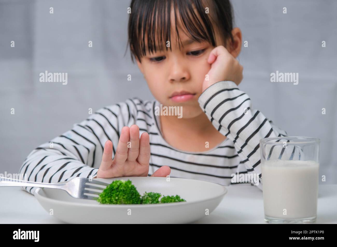 Children don't like to eat vegetables. Cute Asian girl refusing to eat ...