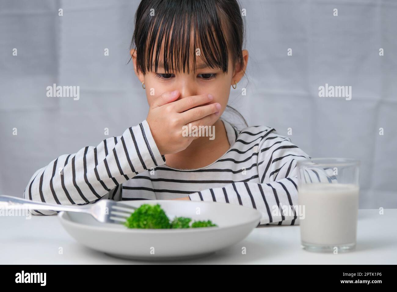 Children don't like to eat vegetables. Cute Asian girl refusing to eat ...
