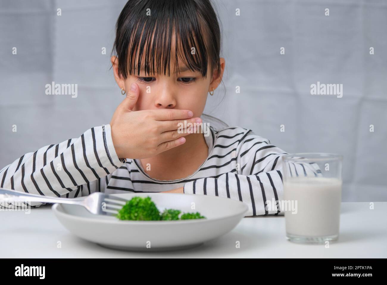 Children don't like to eat vegetables. Cute Asian girl refusing to eat ...