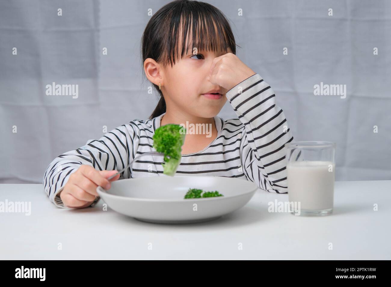 Children don't like to eat vegetables. Cute Asian girl refusing to eat ...
