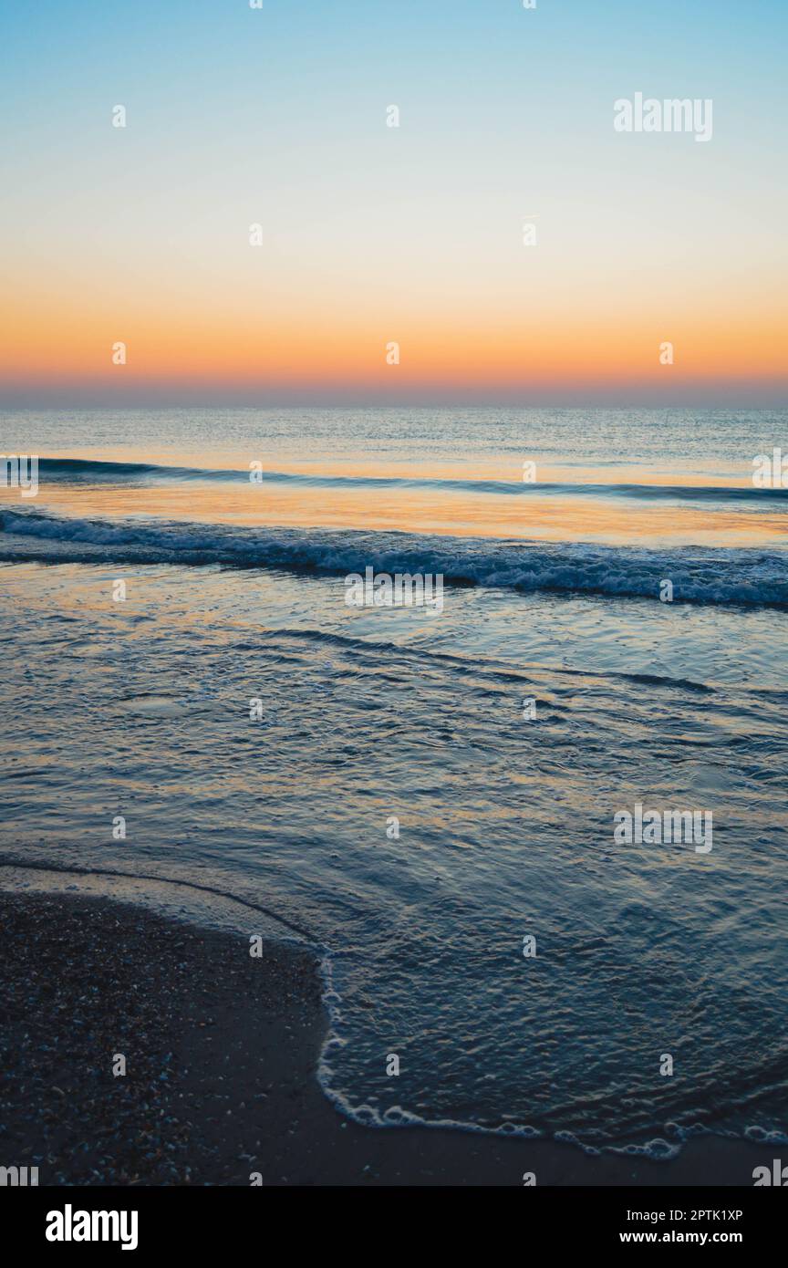 Beautiful summer landscape, sunset at the beach, sparkly sand and waves ...