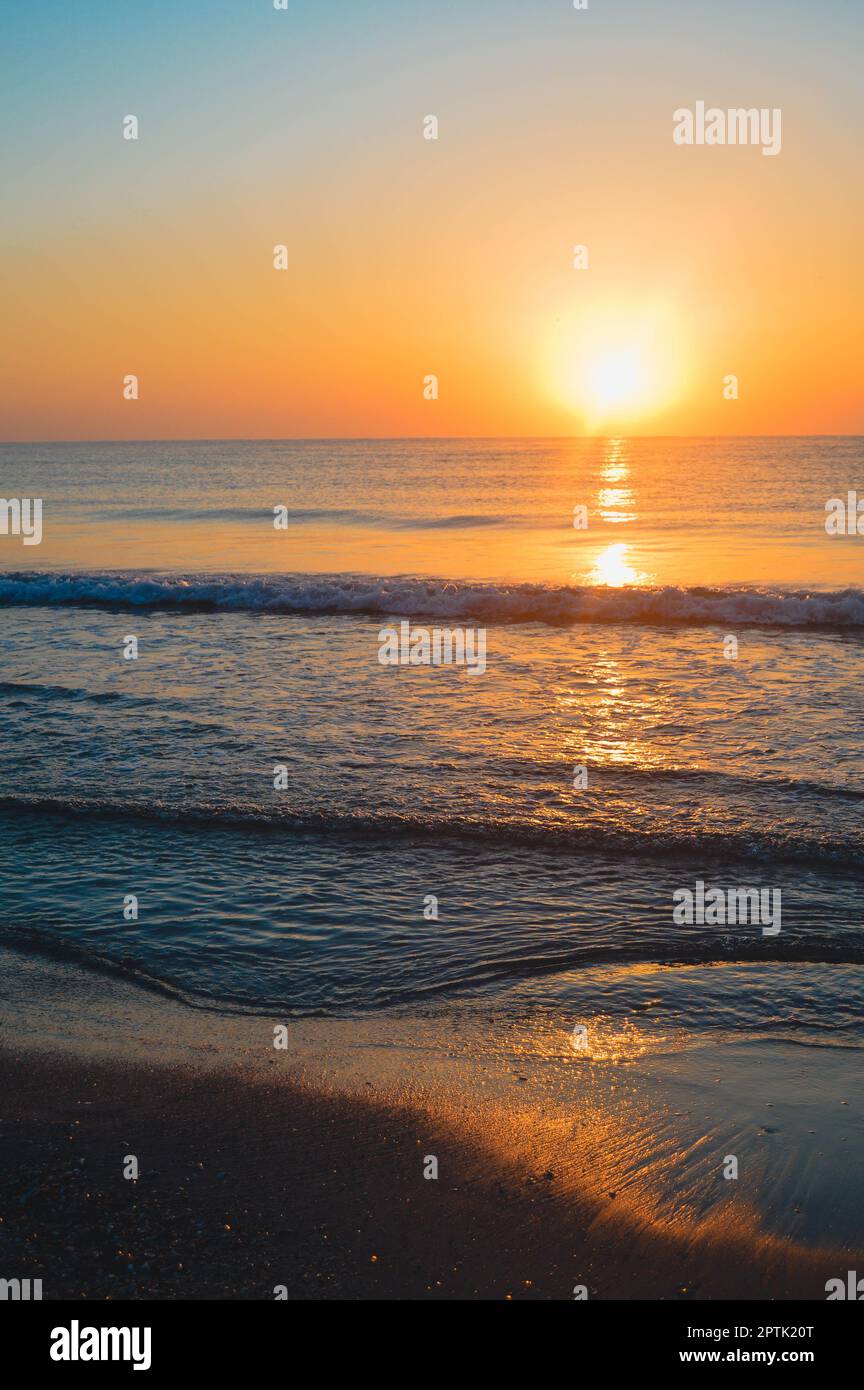 Beautiful summer landscape, sunset at the beach, sparkly sand and waves ...