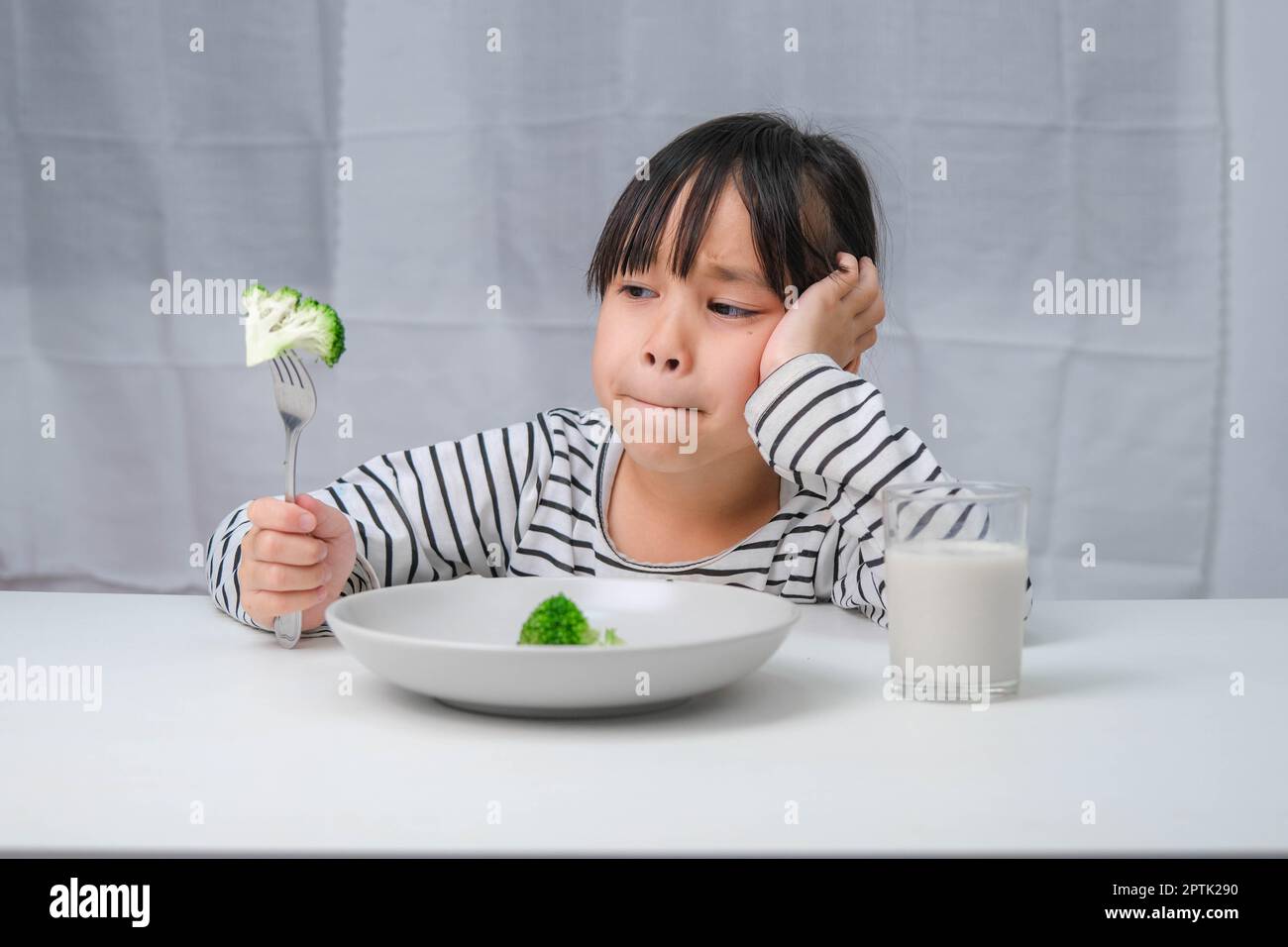 Children don't like to eat vegetables. Cute Asian girl refusing to eat ...