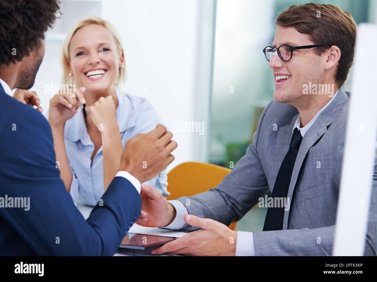 Positive office connections. three colleagues in an office laughing in ...