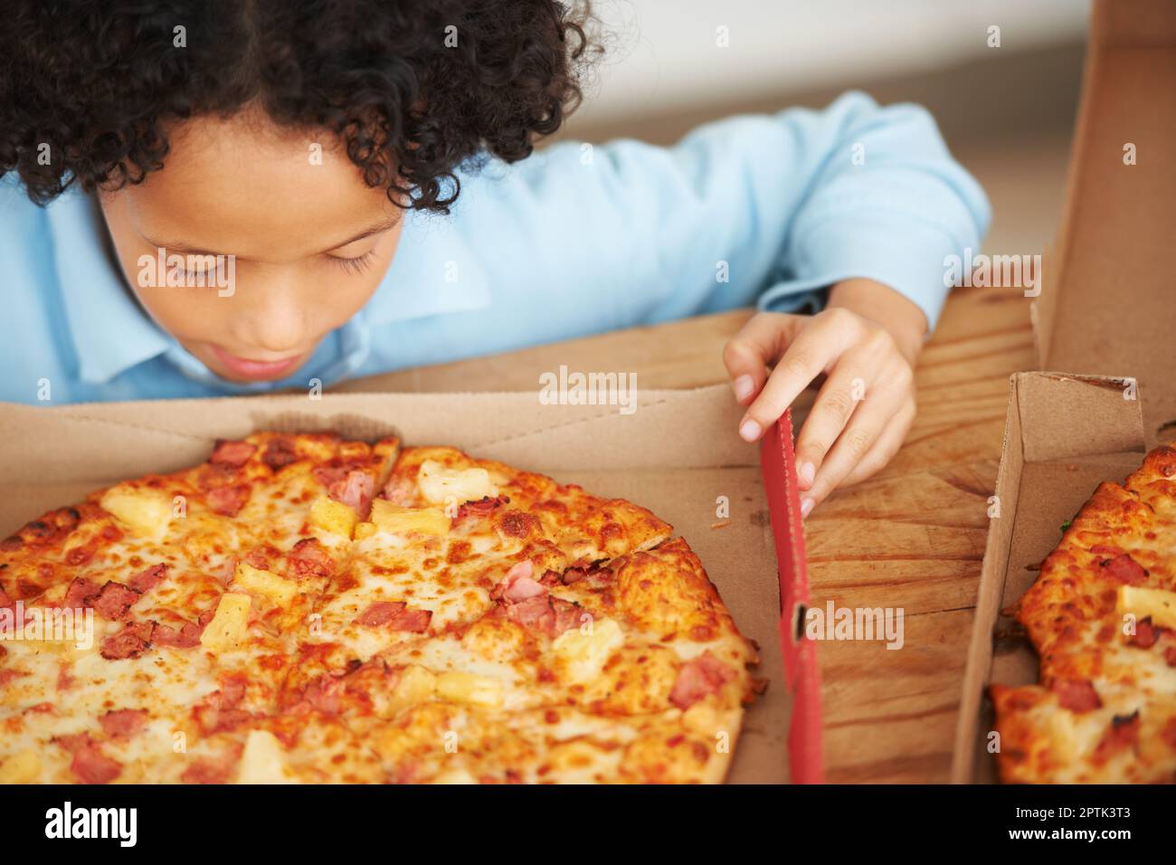 Hawaiian pizza is the best. A cute young boy looking at the pizza in front of him Stock Photo ...