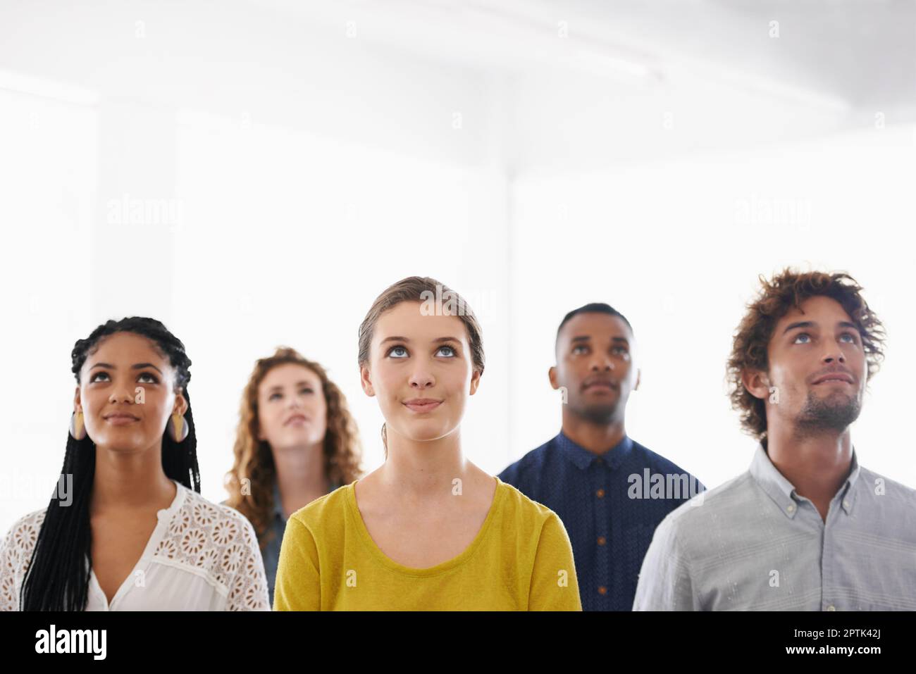 Things are looking up. a group of work colleagues looking up at ...