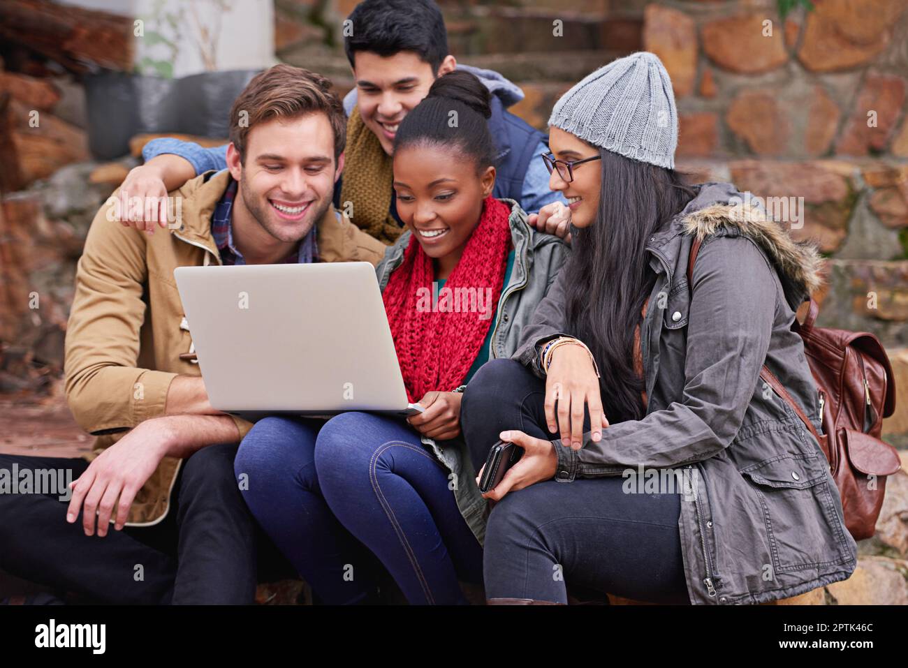 Studying as a group. university students using a laptop while sitting ...