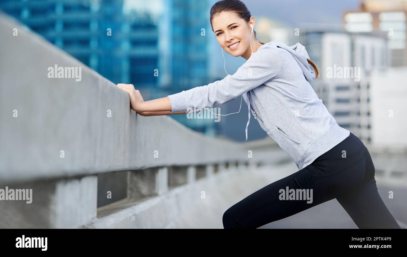 Getting ready for an urban run. Portrait of a young female jogger ...