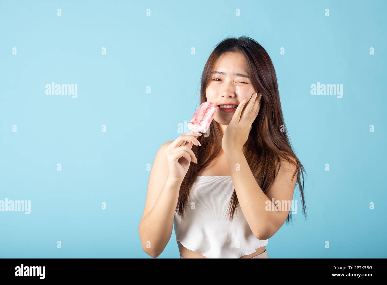 Portrait of Asian young woman with sensitive teeth after eating ...