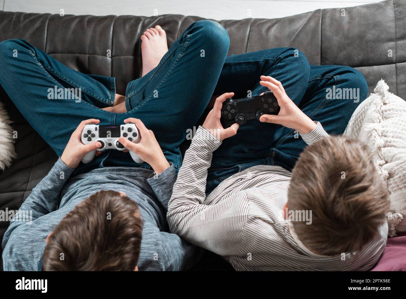 Top view of two teenage boys children sitting on grey sofa at home ...