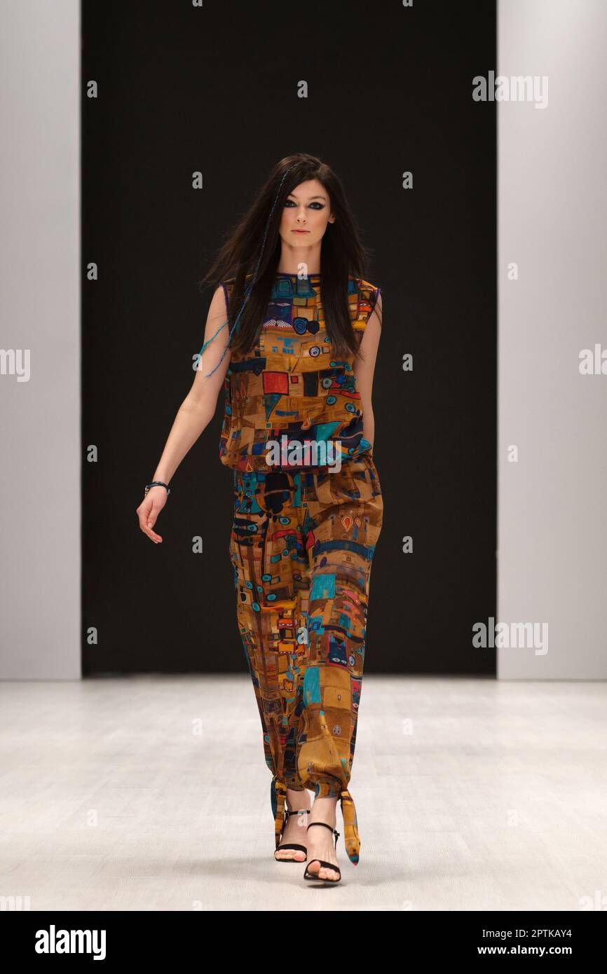 Fashion model in silk dress walking on podium during fashion week show ...