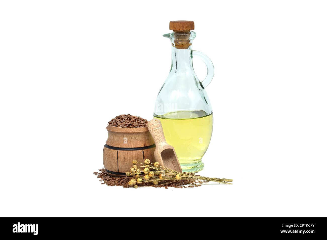 Linseed oil in glass decanter and linseed in wooden scoop near bunch of flax plants isolated on ...