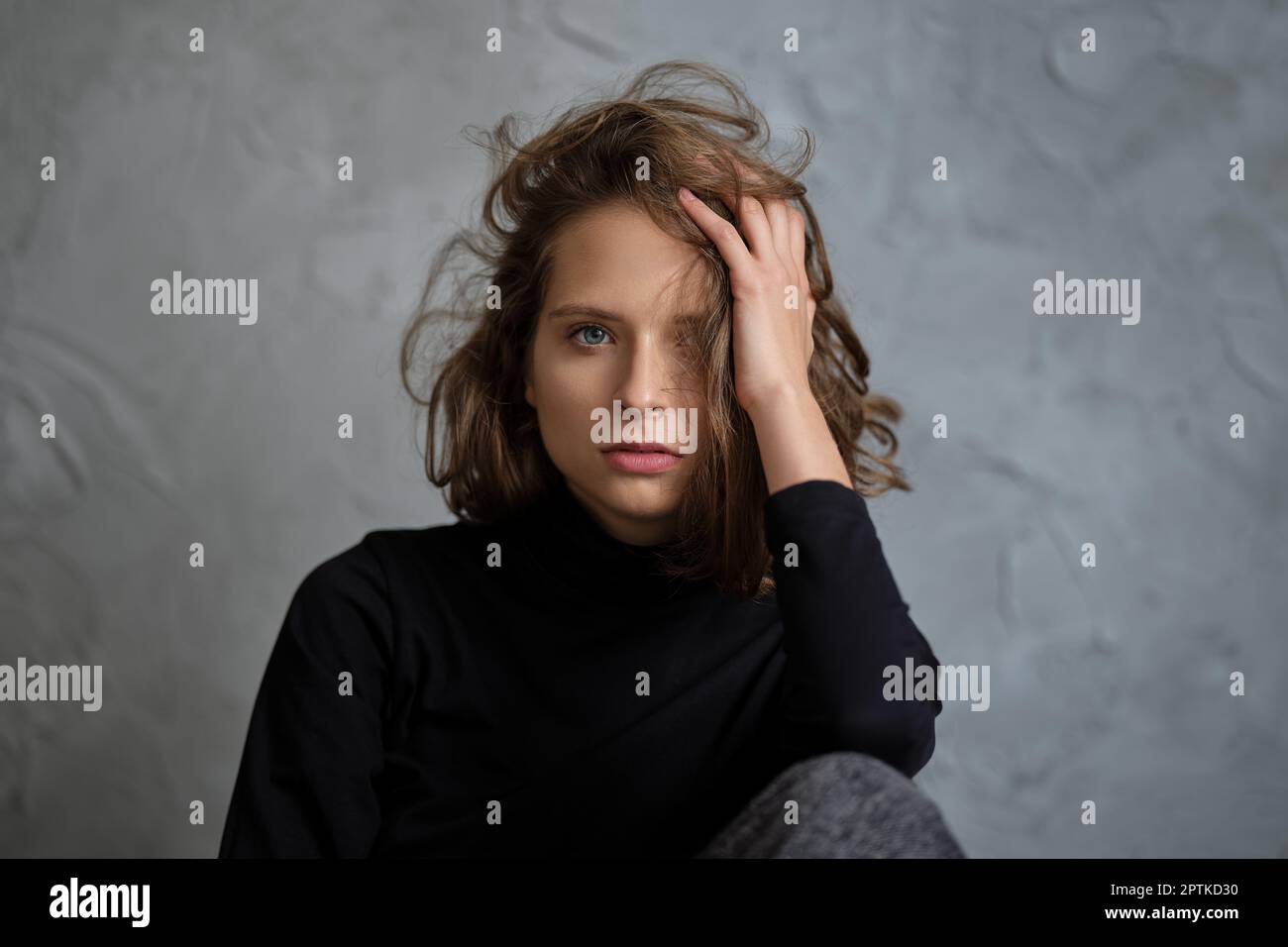 Closeup portrait of young lady proping up head with her arm Stock Photo ...