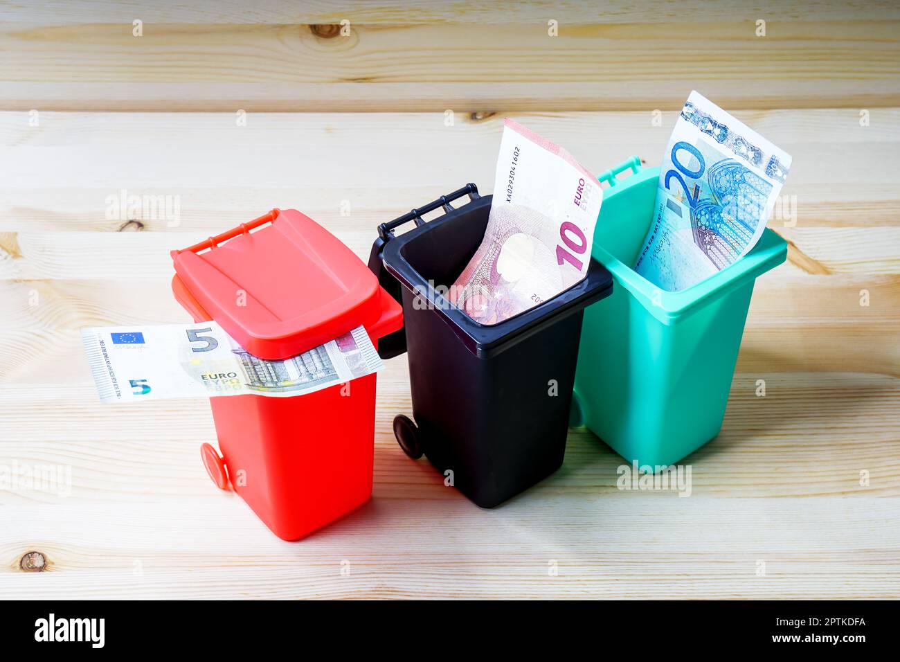 Euro banknote in a garbage can as a symbol for garbage fees, waste of ...