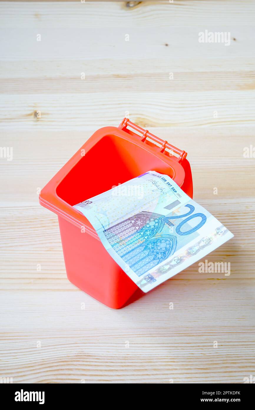 Euro banknote in a garbage can as a symbol for garbage fees, waste of ...