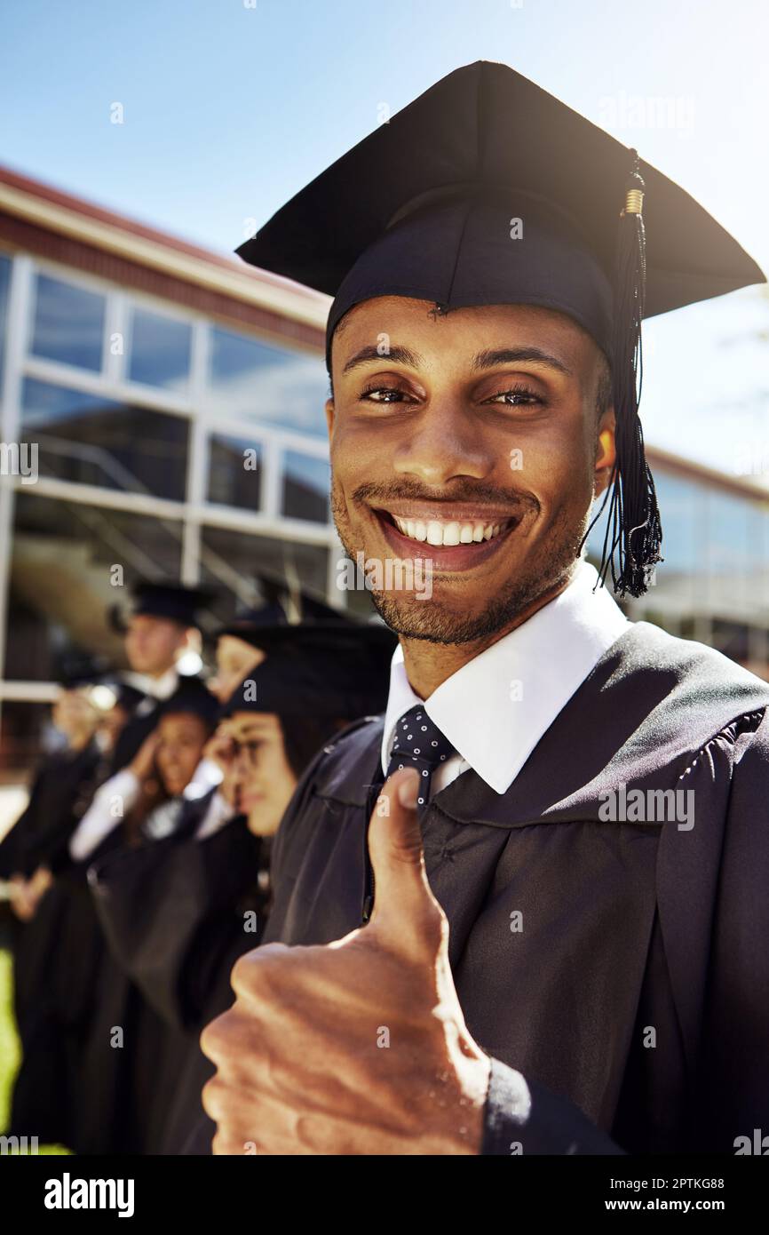 I did it. Portrait of a smiling university student giving the thumbs up ...