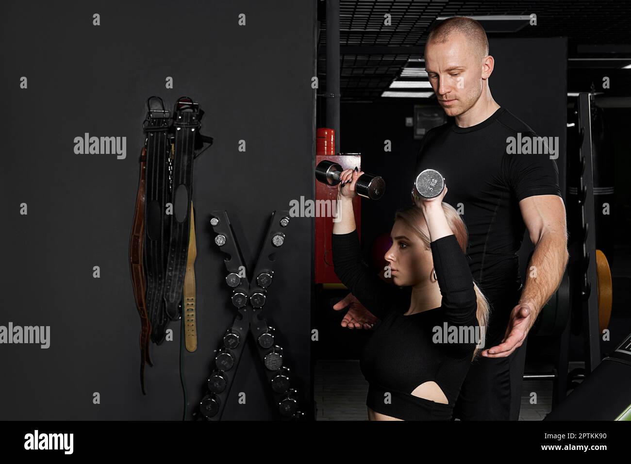 Coach shows to woman how to train in gym to lose weight. Dumbbell ...