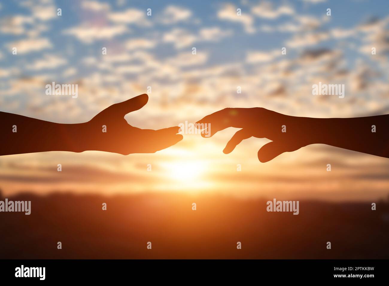 Silhouette of reaching, giving a helping hand, hope and support each other over sunset ...