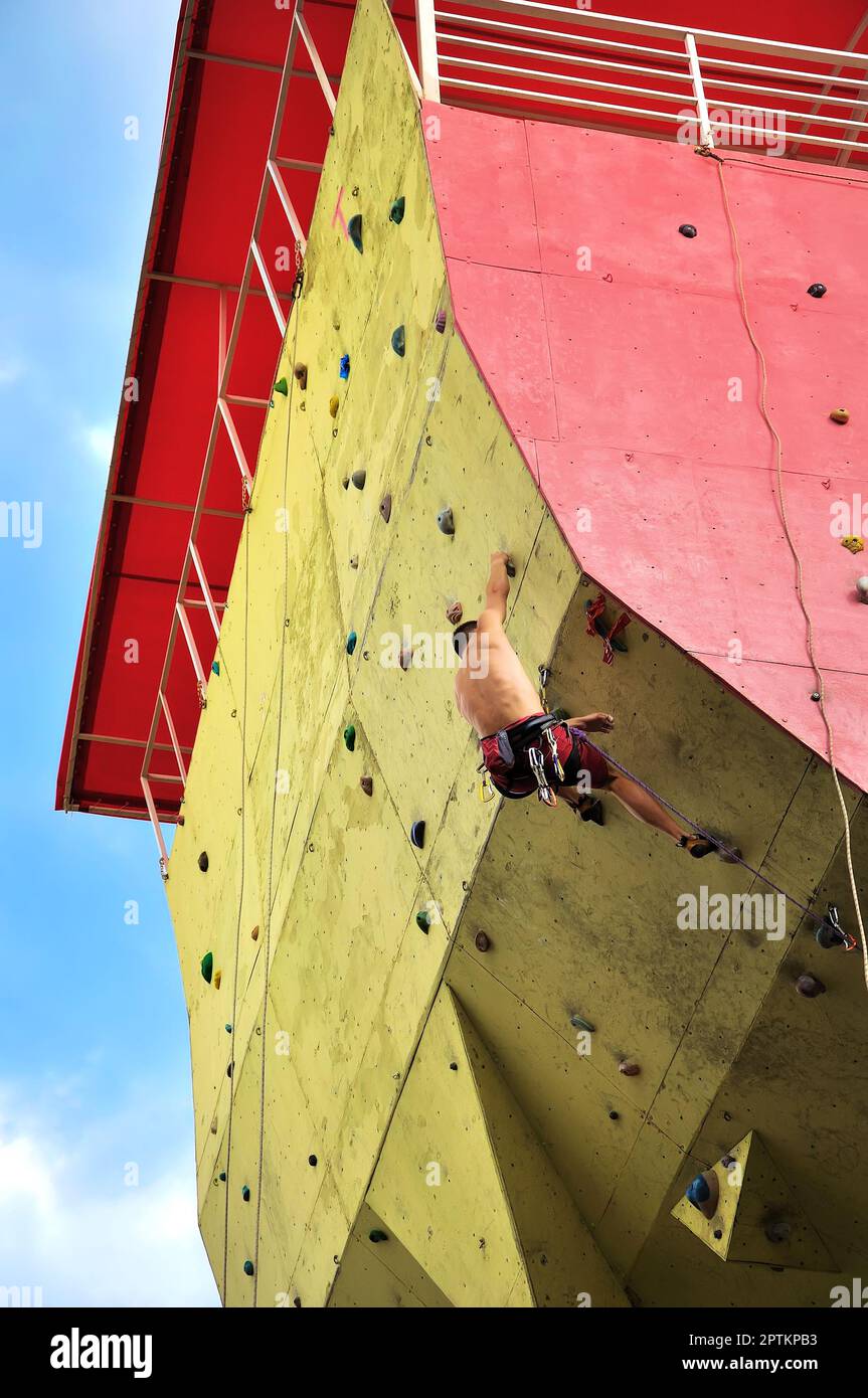 Muscular man climbing on a wall Stock Photo - Alamy