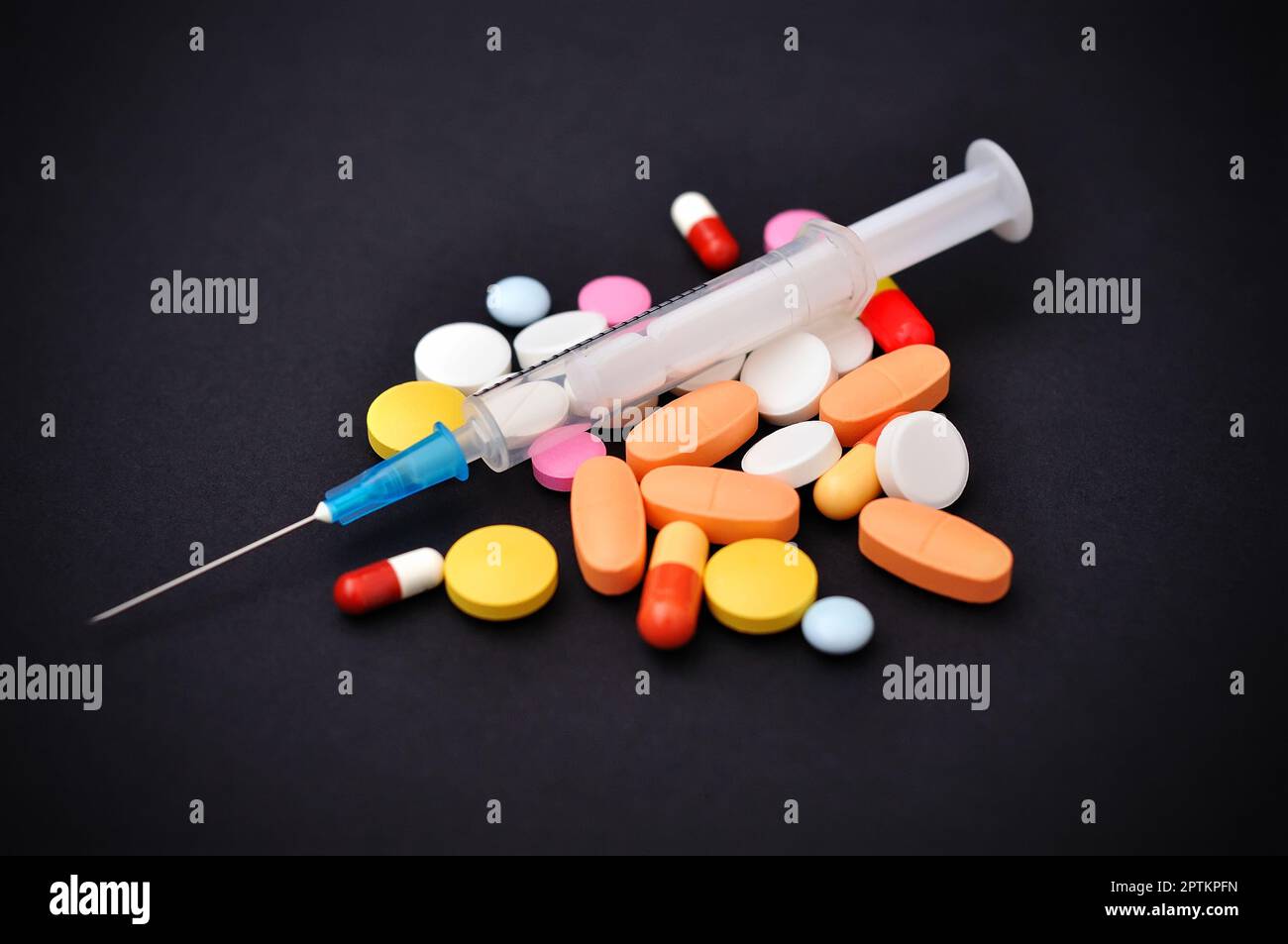 narcotic tablets and syringe on a black background Stock Photo - Alamy
