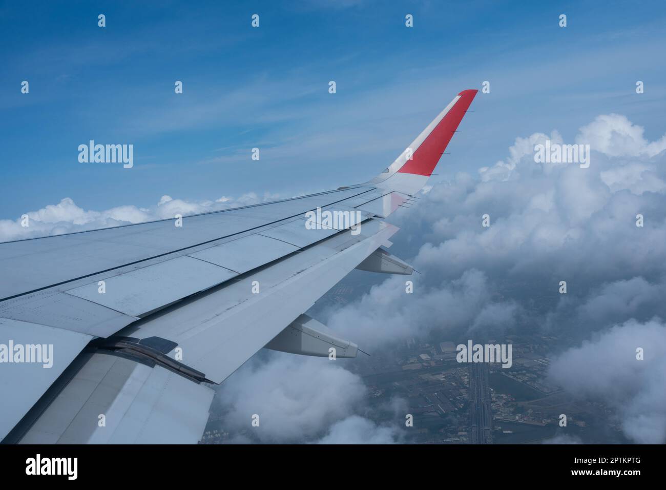 Airplane wing flying above the sky with white clouds. View from ...