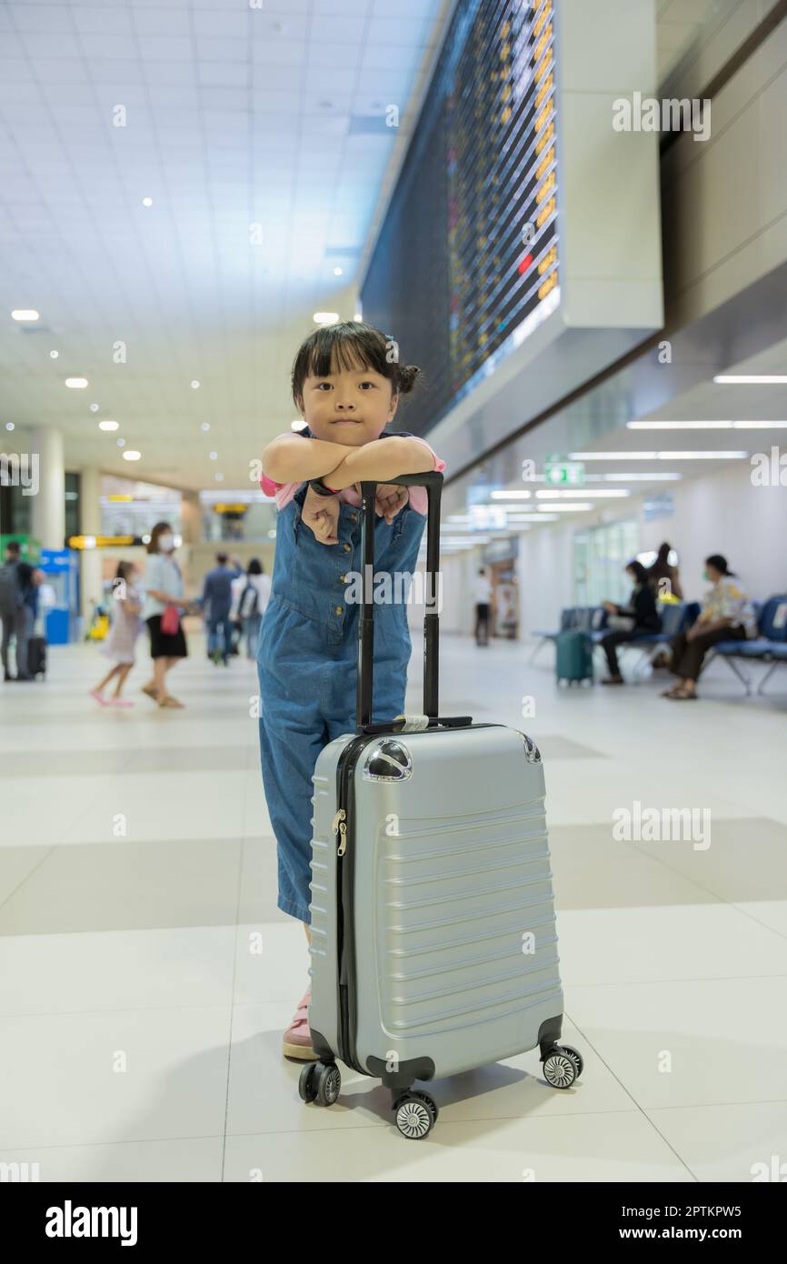 Cute happy child girl with suitcase at airport terminal. Kid and family ...